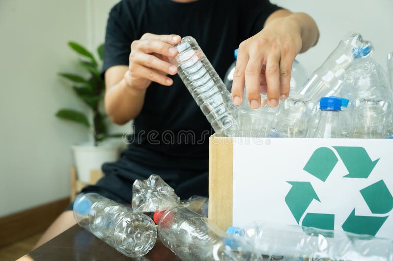 A Person is Sorting through a Pile of Plastic Bottles, Including Some ...