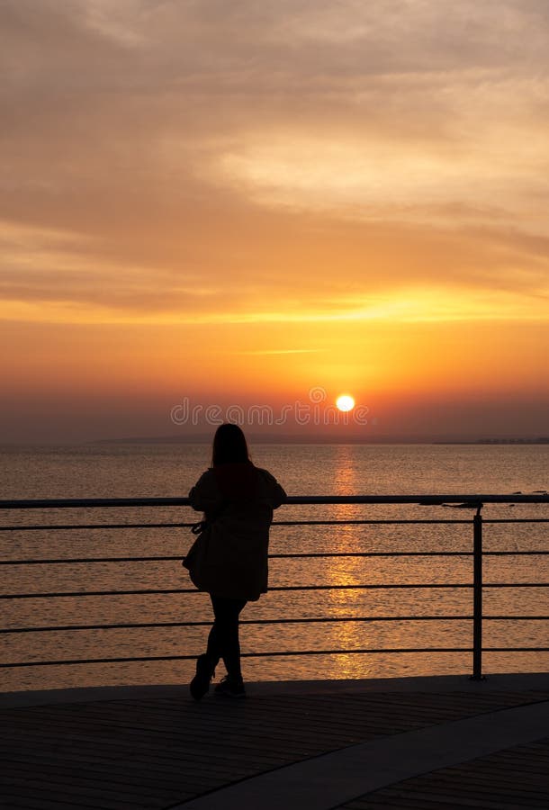 Person Standing Alone on a Pier Enjoying Dramatic Sunset at the Sea ...