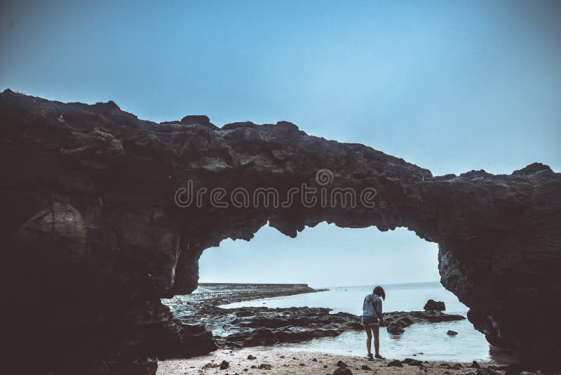 Person Standing on Beach Under Rock Stock Image - Image of outdoors ...