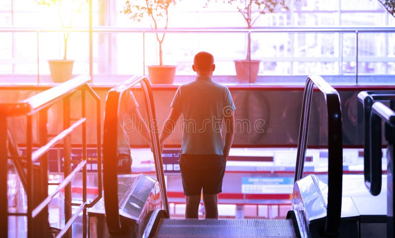 Person Standing on Escalator with Bright Sunlight Entering from Large ...