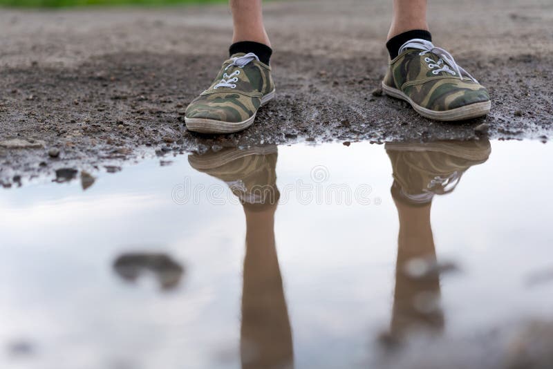 A Person is Standing in a Puddle of Water with Their Feet in the Water ...