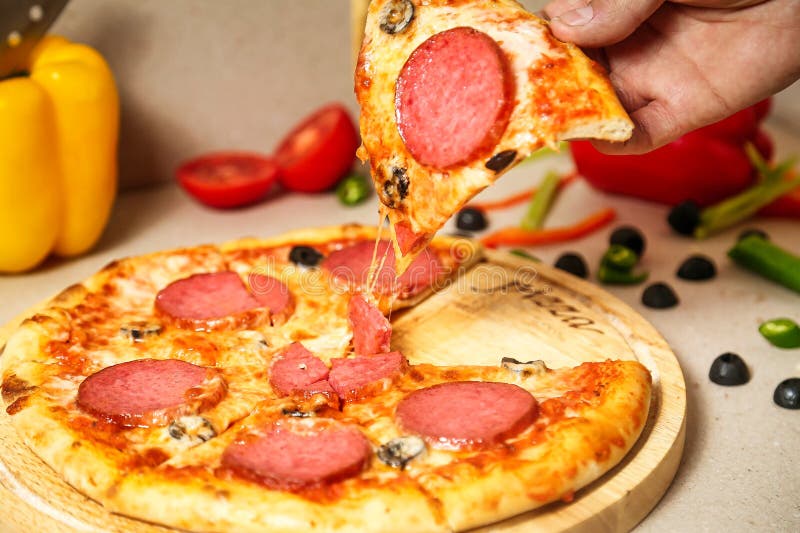 Person Taking a Slice of Pepperoni Pizza at a Restaurant Stock Photo ...