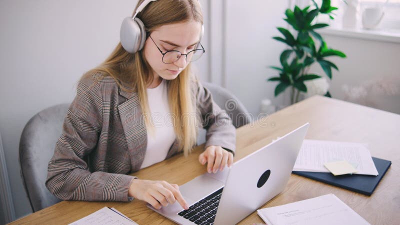 Individual Working on a Laptop at a Wooden Table with Documents ...
