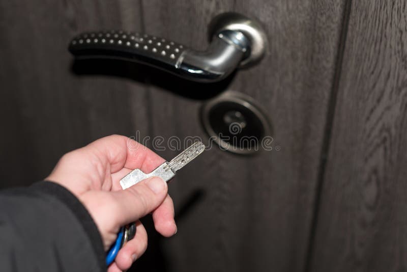 Person Unlocking a Modern Door Using a Key, Signifying Security and ...