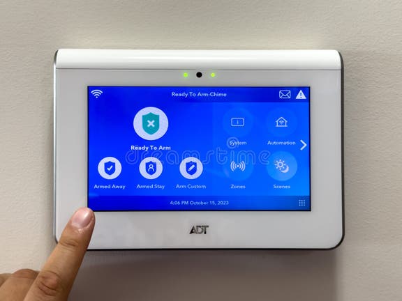 A Person Using an ADT Security Touch Screen Panel Control on a Wall ...
