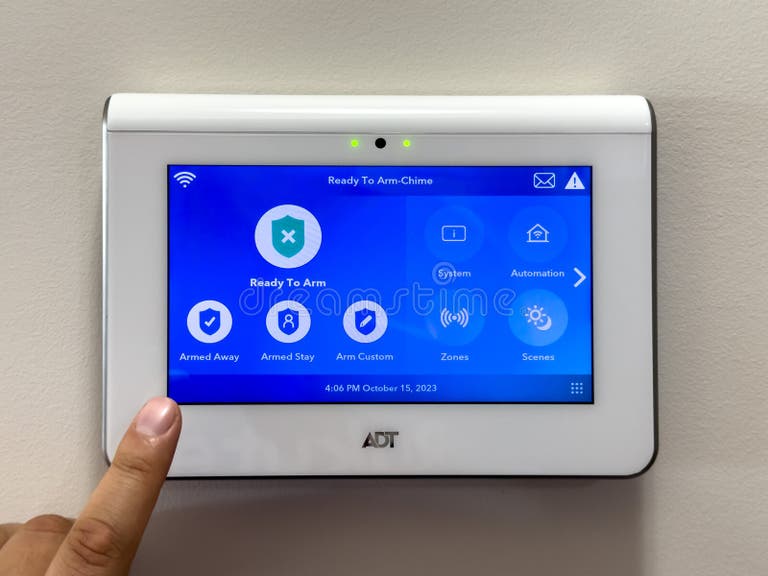 A Person Using an ADT Security Touch Screen Panel Control on a Wall ...