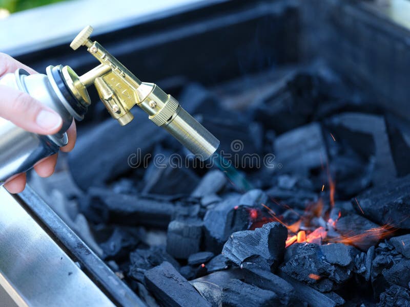 Person Using a Blowtorch To Light Charcoal in a Grill Stock Photo ...