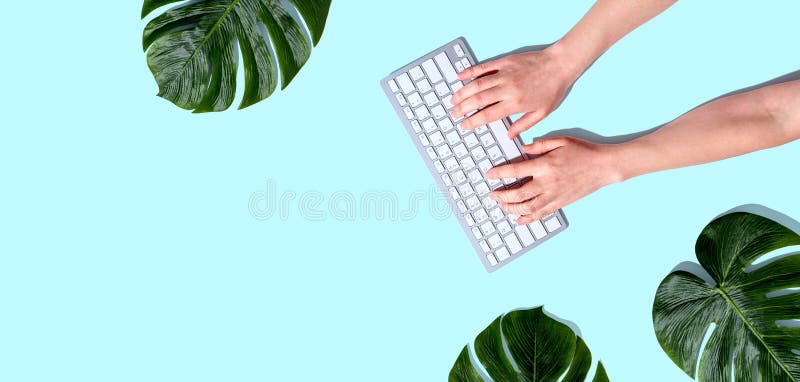 Person Using a Computer Keyboard with Tropical Leaves Stock Photo ...