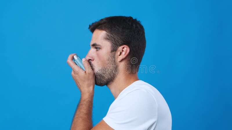 Person Using an Inhaler Against a Blue Background in a Calm Setting ...