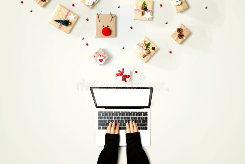 Person Using a Laptop Computer with Christmas Gift Boxes Stock Photo ...