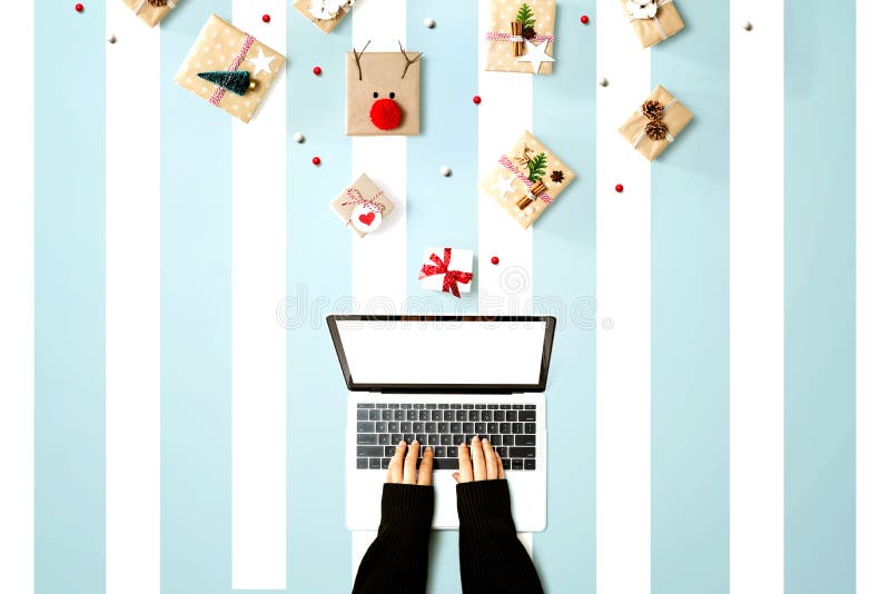 Person Using a Laptop Computer with Christmas Gift Boxes Stock Photo ...