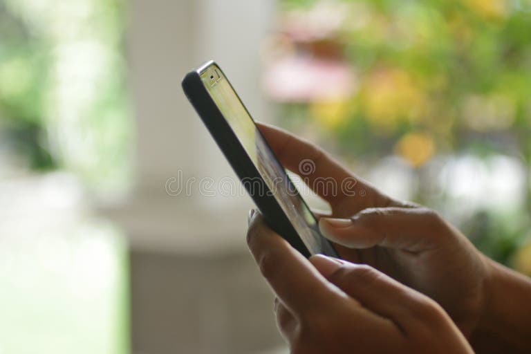 Person Using Mobile Phone on Bright Bokeh Light Background with Copy ...