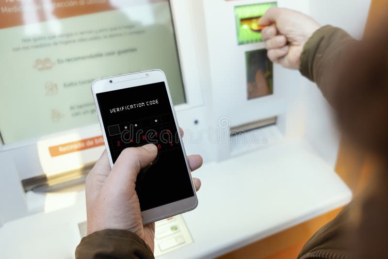 Person Using Mobile Phone with Verification Code at an ATM. Security ...