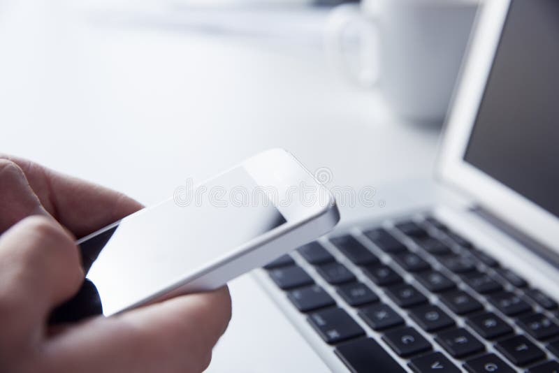 Person Using Phone while Working on a Laptop Stock Image - Image of ...