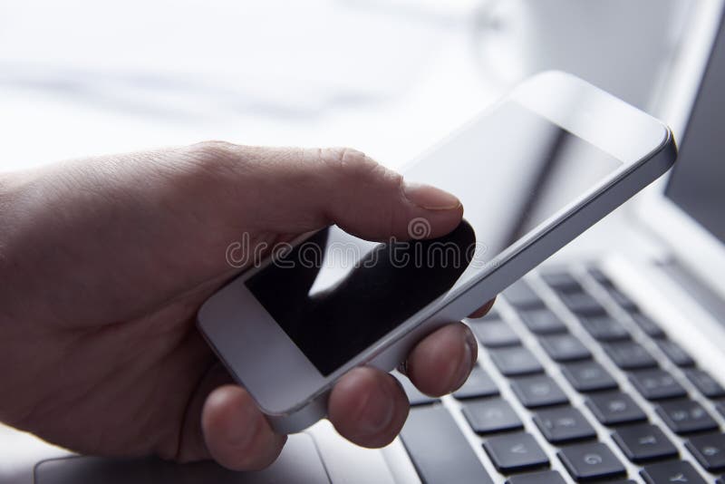 Person Using Phone while Working on a Laptop Stock Image - Image of ...