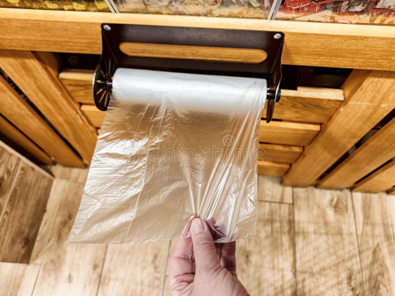Person Using Plastic Wrap Dispenser in a Kitchen Setting To Cover Food ...