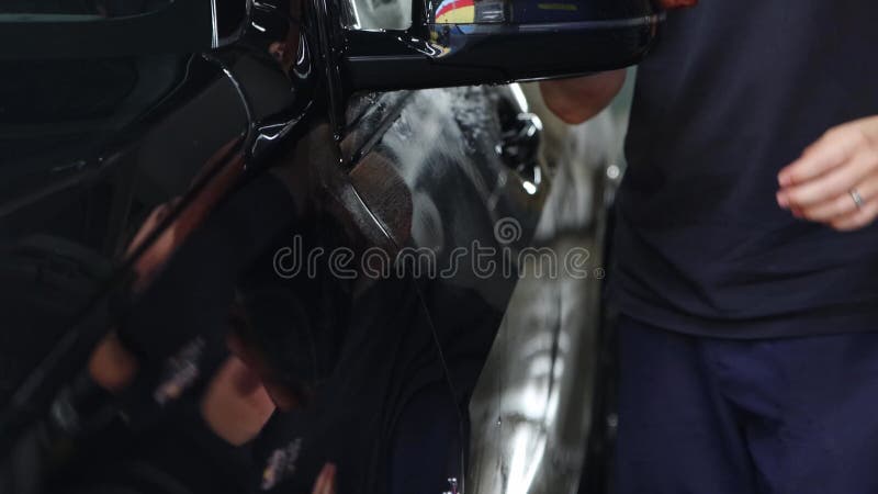 A Person Using a Rag with the Black Car Against the Surface Stock Video ...