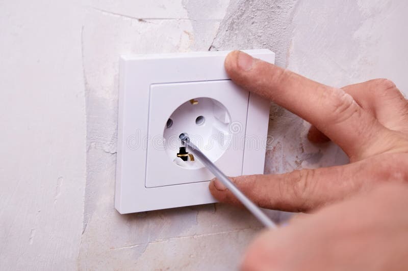 A Person is Using a Screwdriver To Install an Electrical Outlet on a ...