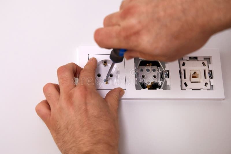 A Person is Using a Screwdriver To Install an Electrical Outlet on a ...
