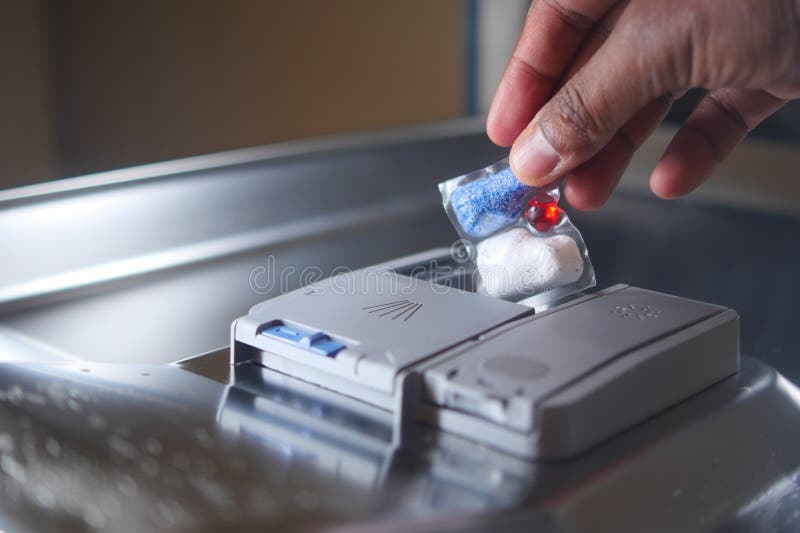 The Person is Using a Soap Dispenser for the Dishwasher with Their Hand ...