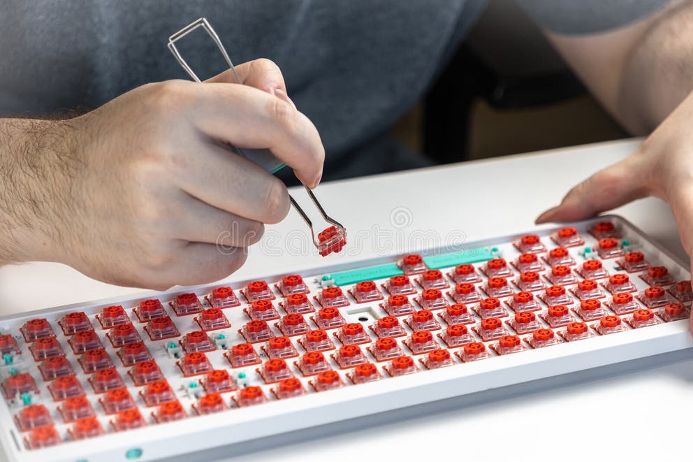 Person Using Switch Puller Tool To Remove Red Switch from Mechanical ...