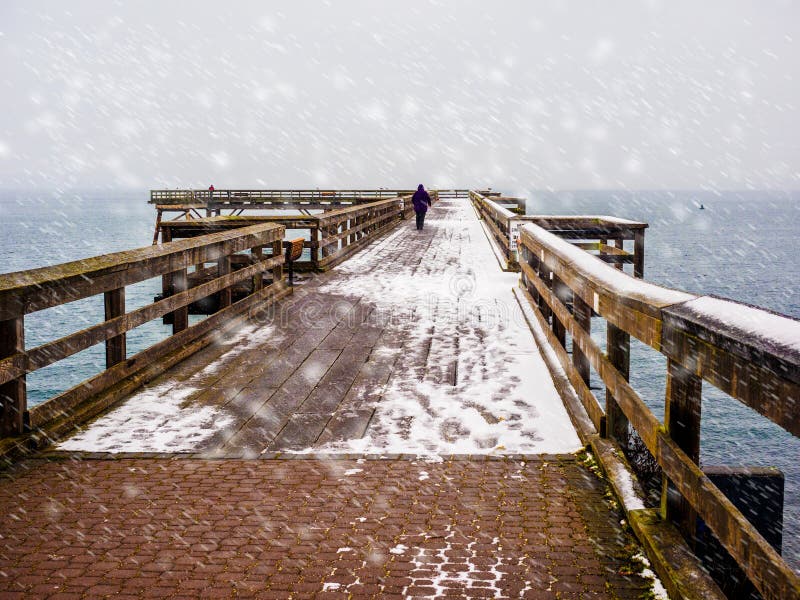 Person Walking through the Snowfall on Ocean Pier Stock Image - Image ...