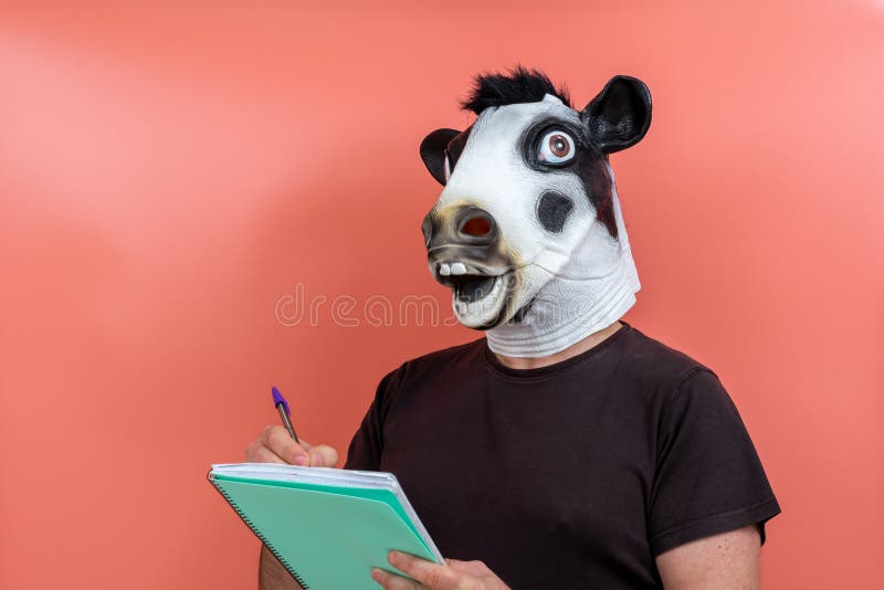 Person Wearing a Cow Mask and Surgical Mask Taking Notes with a Pen on ...