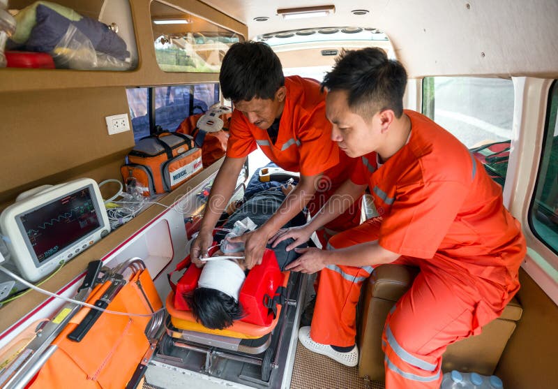 A Person is Wearing an Oxygen Mask, Getting Help from Paramedic in ...