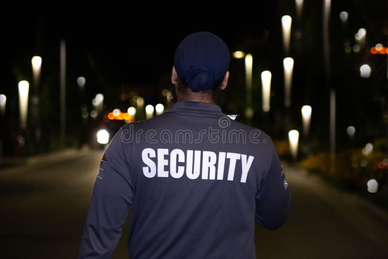 Person Wearing a Uniform with "security" on Its Back, Walking on the ...