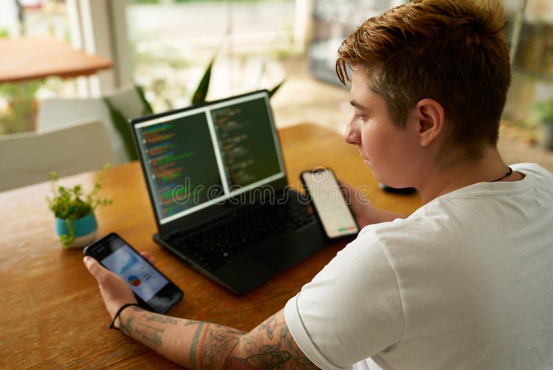 Person at Wooden Desk Engages in Intense Multitasking with Two ...