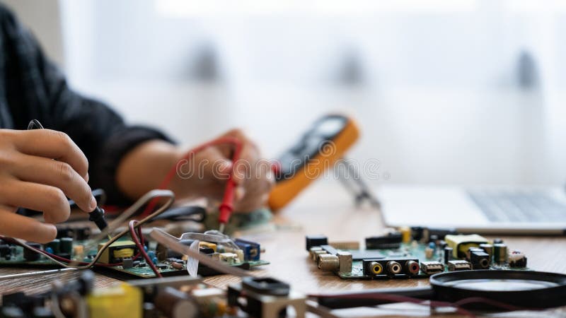 A Person is Working on a Computer Part, Writing on a Piece of Paper ...