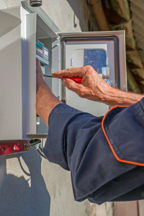 A Person Working on the Installation of Electrical Meter Equipment ...