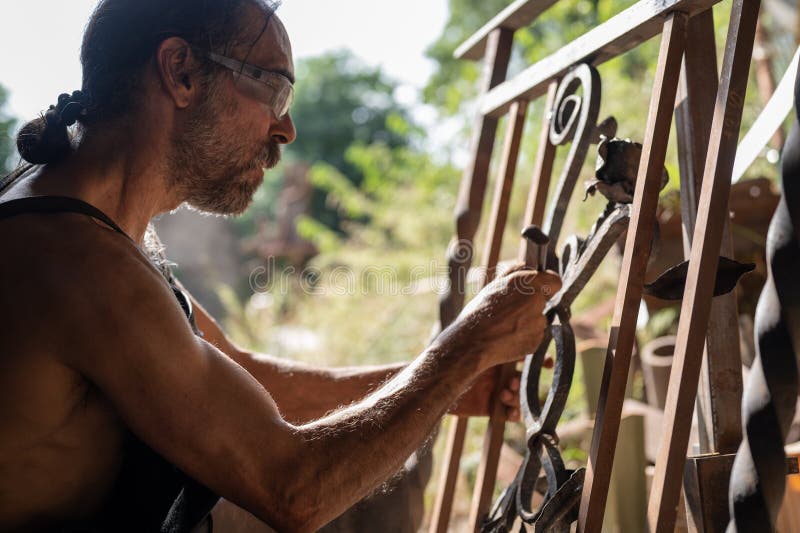Person Working on an Iron Grill in Workshop. Stock Image - Image of ...