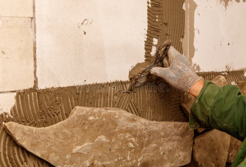 A Person is Working on a Wall, Using a Trowel To Apply a Layer of ...