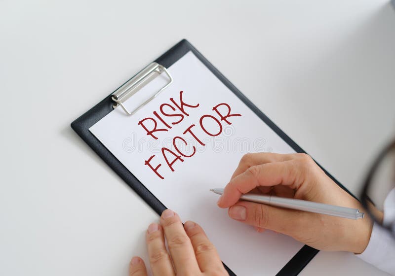 A Person is Writing on a Clipboard with the Word Risk Factor Written in ...