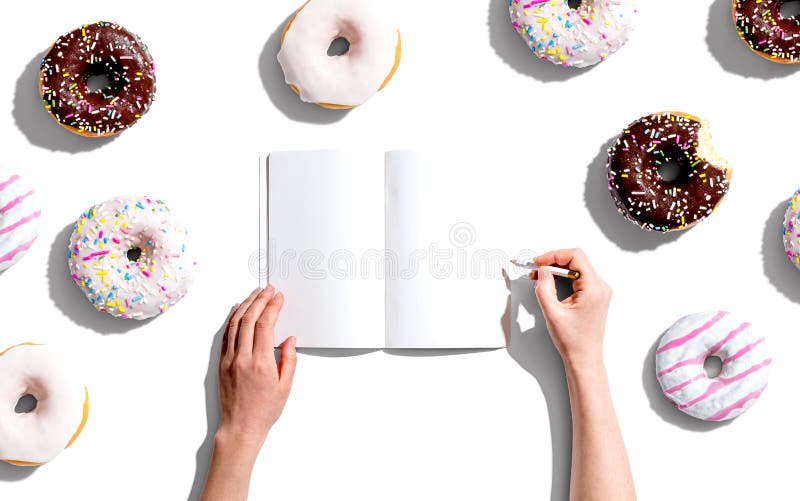 Person Writing in a Notebook with Donuts Stock Image - Image of ...