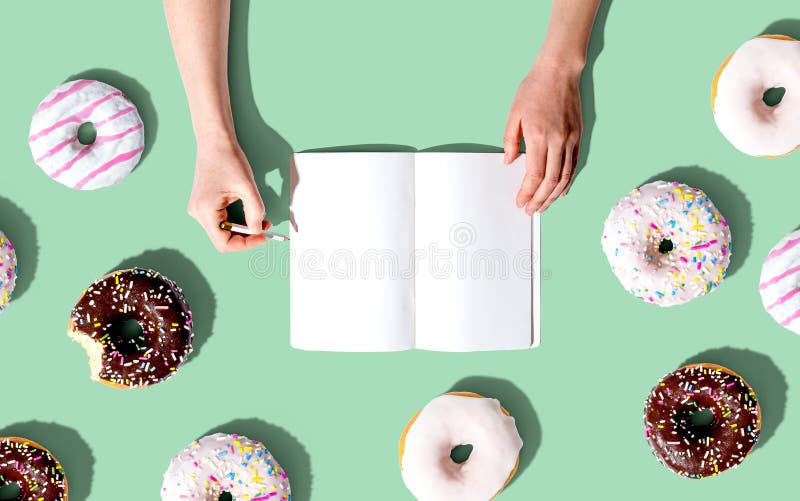 Person Writing in a Notebook with Donuts Stock Photo - Image of page ...