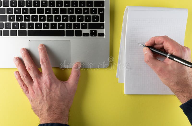 Person Writing on Notepad while Working on Laptop Computer Stock Photo ...