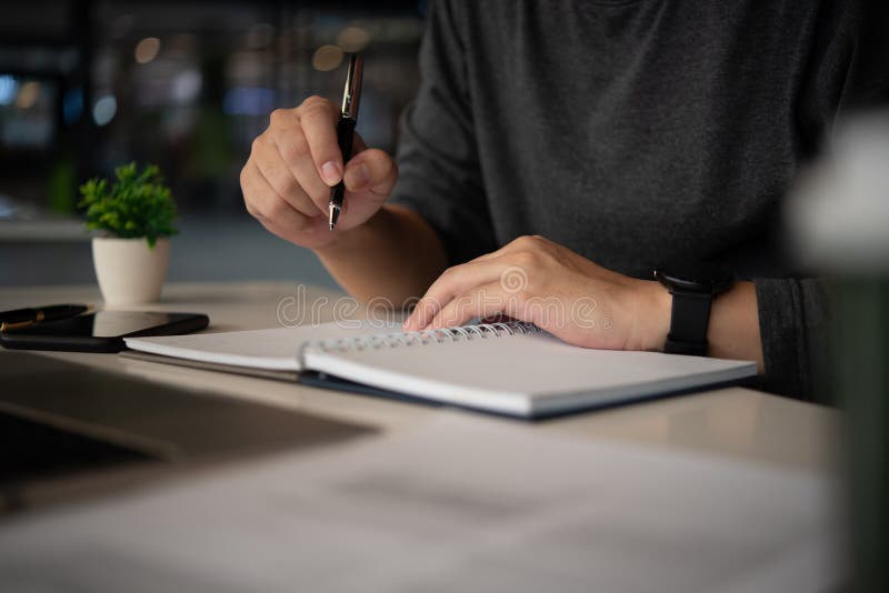 Person Writing Notes in a Notebook in an Office Setting, Capturing the ...