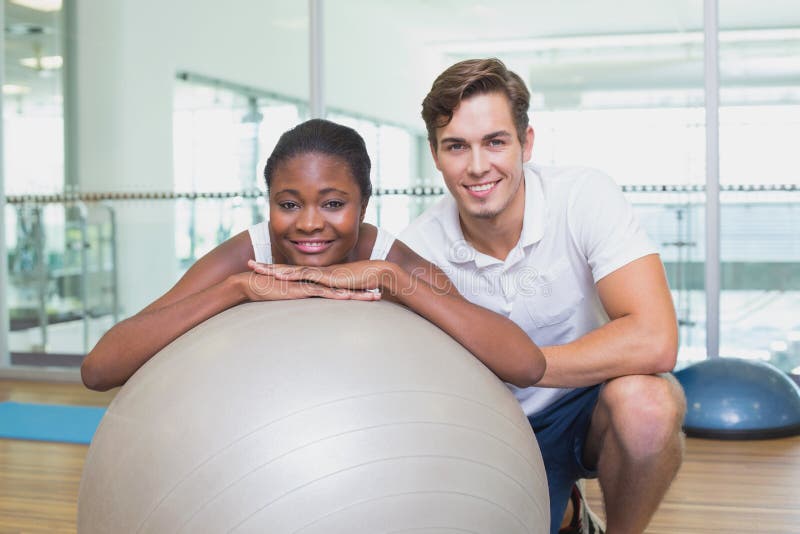 Personal Trainer and Client Smiling at Camera with Exercise Ball Stock ...