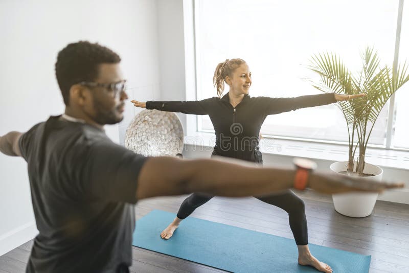 Personal Trainer Doing Yoga Pose in Sunny Studio with Client Stock ...