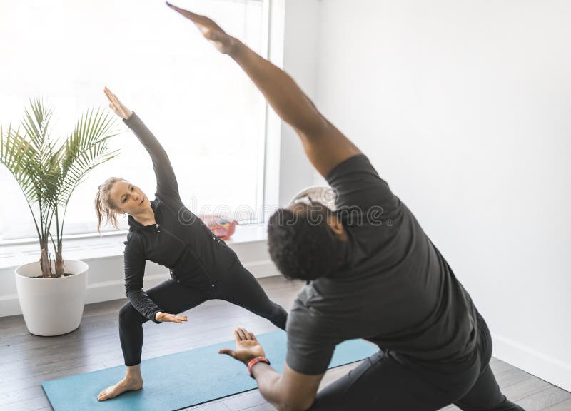 Personal Trainer Doing Yoga Pose in Sunny Studio with Client Stock ...