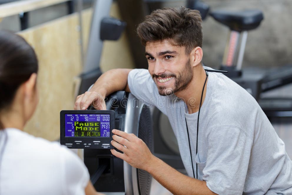 Personal Trainer Explaining Digital Controls on Exercise Machine Stock ...