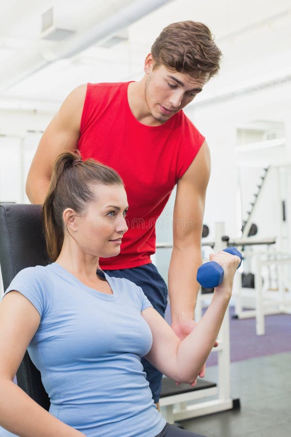 Personal Trainer Helping Client Lift Dumbbell Stock Image - Image of ...