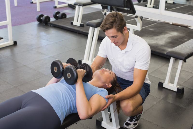 Personal Trainer Helping Client Lift Dumbbells Stock Image - Image of ...