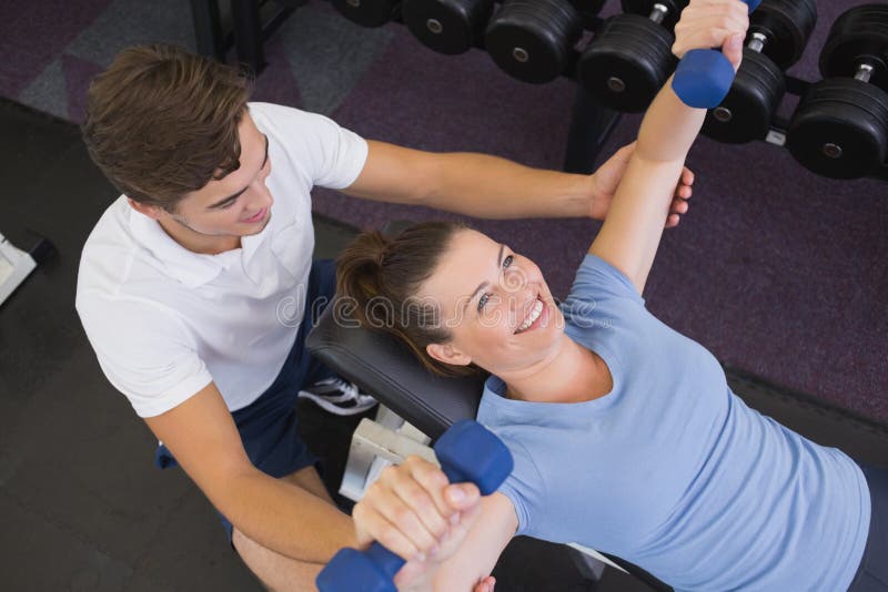 Personal Trainer Helping Client Lift Dumbbells Stock Image - Image of ...