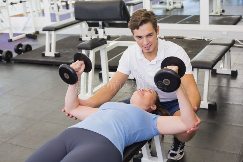 Personal Trainer Helping Client Lift Dumbbells Stock Image - Image of ...