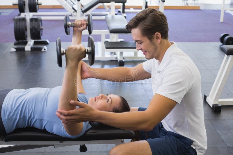 Personal Trainer Helping Client Lift Dumbbells Stock Photo - Image of ...