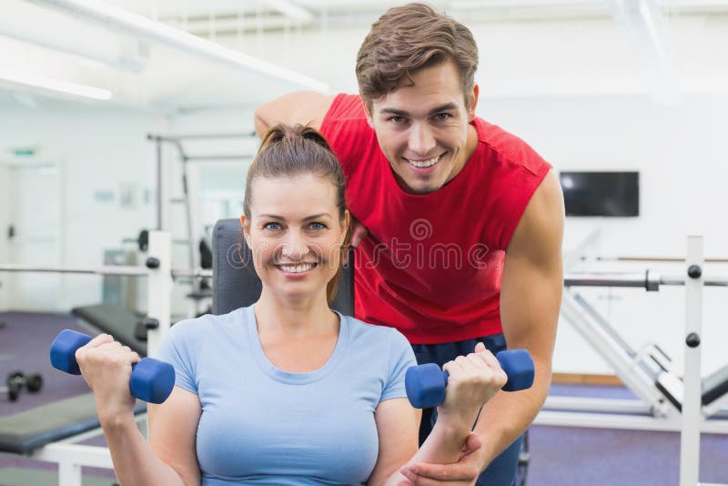 Personal Trainer Helping Client Lift Dumbbells Stock Photo - Image of ...