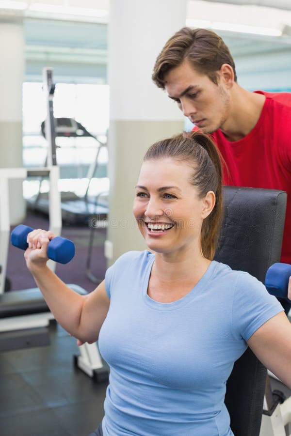 Personal Trainer Helping Client Lift Dumbbells Stock Photo - Image of ...